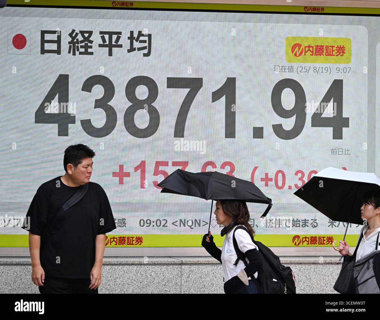 A monitor shows the Nikkei Stock Average hitting a new high during ...
