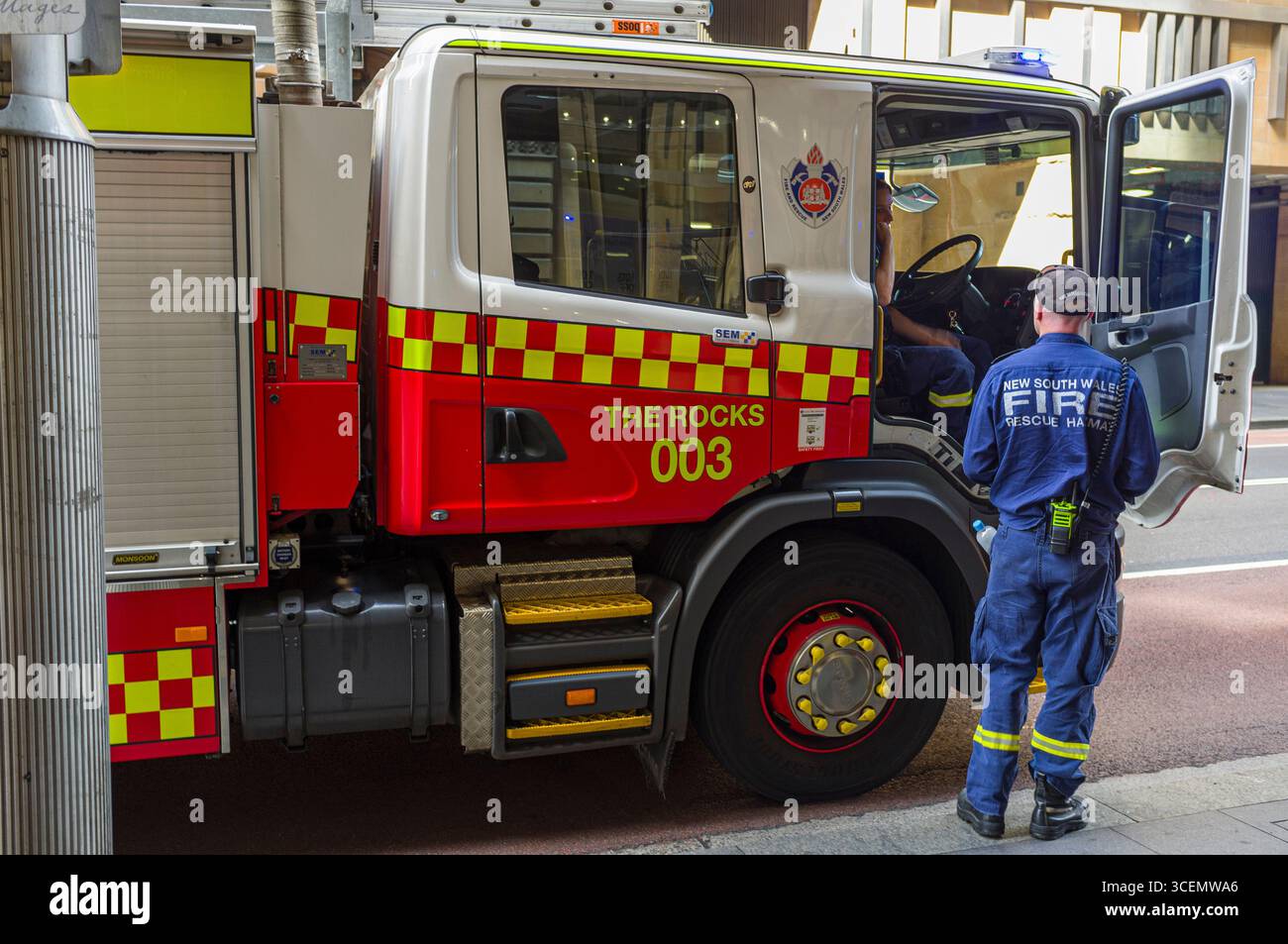 Fireman in blue uniform standing outside a Scania water/rescue tender ...