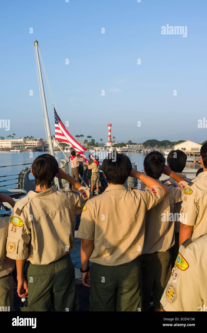 Group of Boy Scouts standing at attention and saluting as the flag of ...