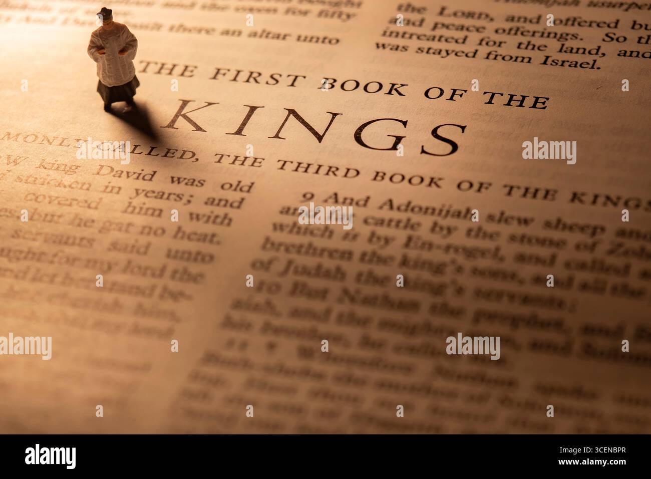 Kings title bible page with a backlit miniature scale model priest ...