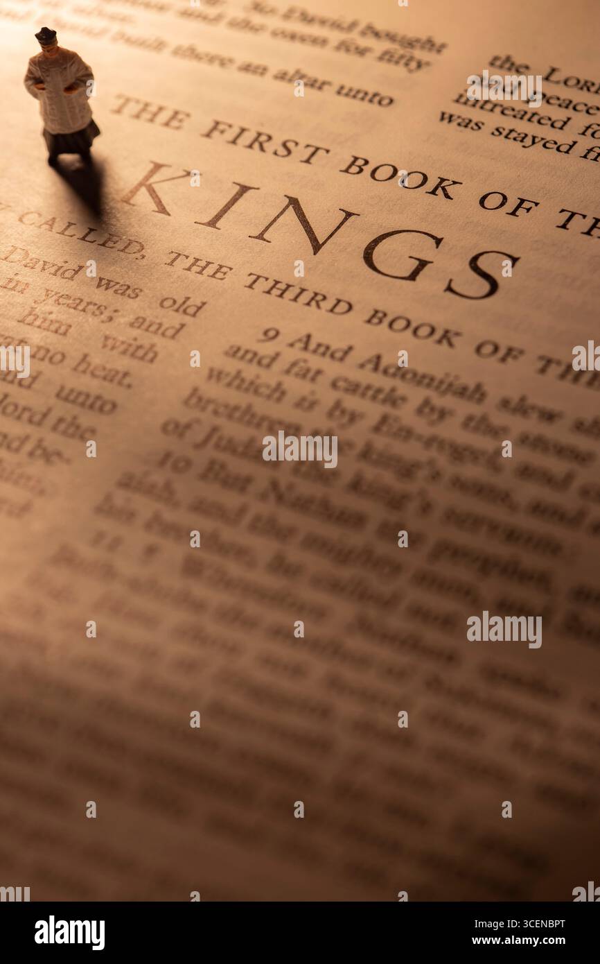 Kings title bible page with a backlit miniature scale model priest ...