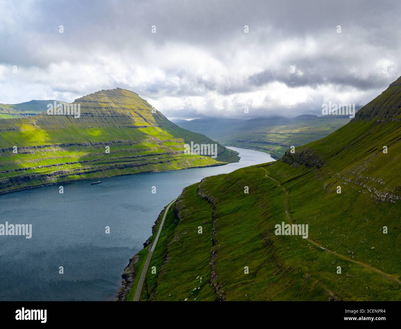 Aerial view of the serpentine fjord cutting through the verdant hills ...