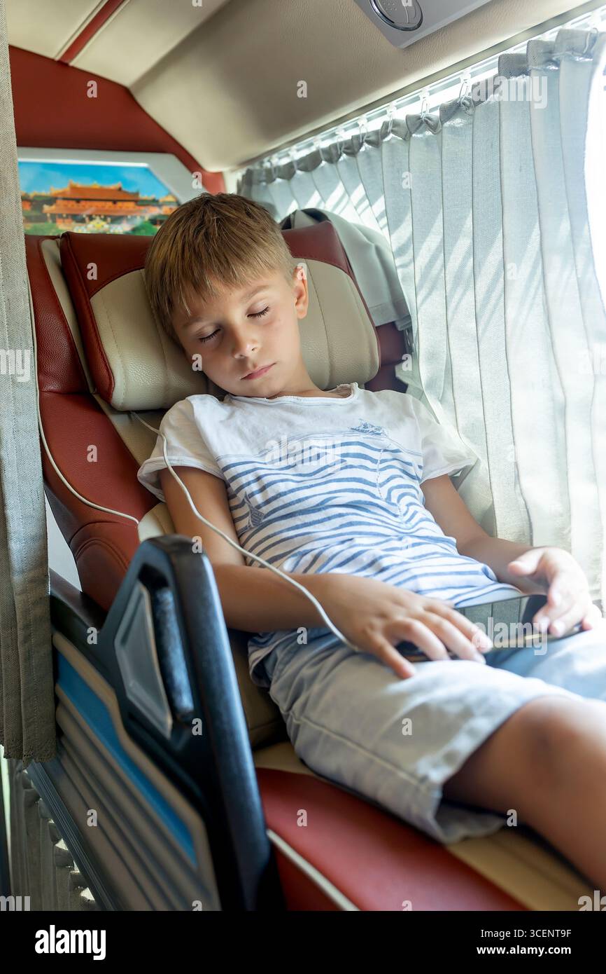 Child, boy, traveling in a sleeper bus in Vietnam, bed seat in the bus ...