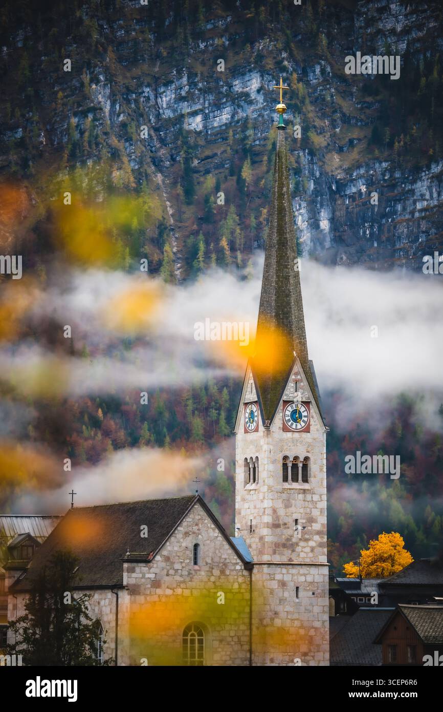 View of a tall church steeple piercing through the soft, ethereal mist ...