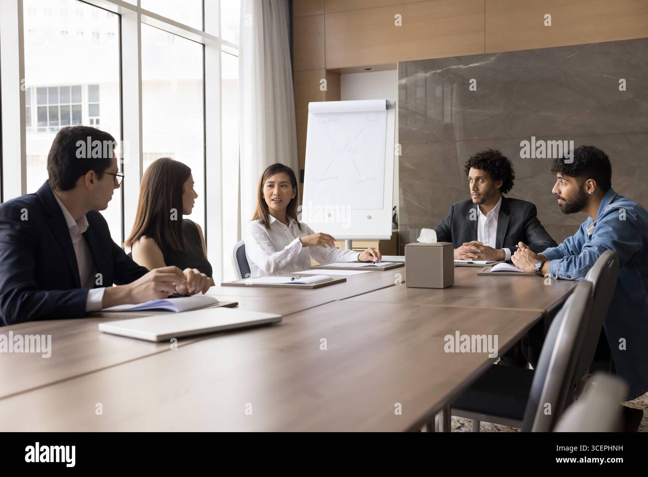 Confident young Asian woman speak to multicultural staff at workshop ...