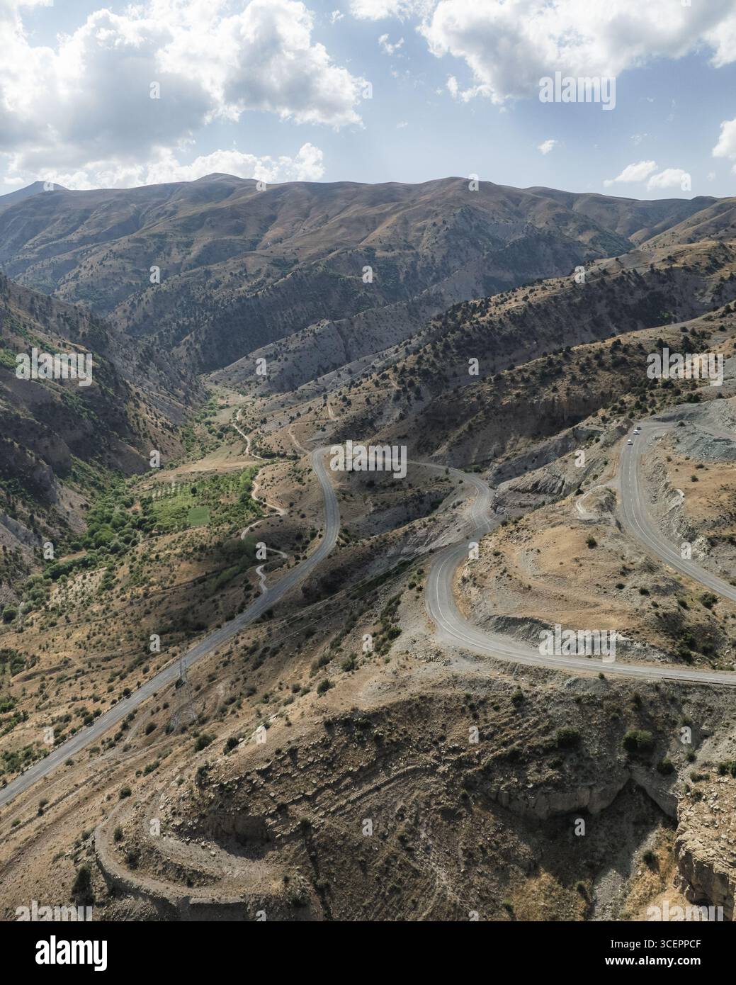 Aerial view of a winding road snakes through the rugged, sun-scorched ...