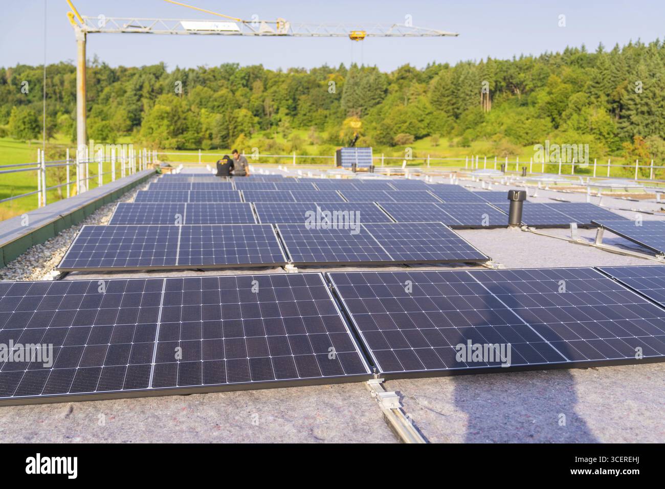Solar modules installed on roof, surrounded by forest and construction ...