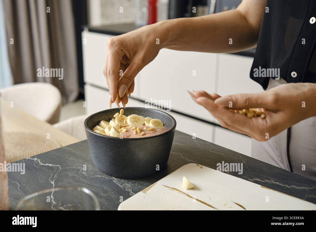 Hand adds fresh banana in hi-res stock photography and images - Alamy