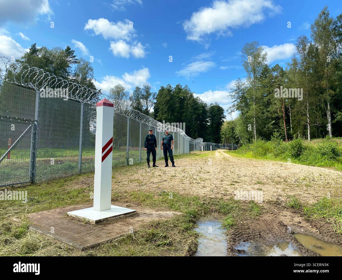 19 August 2025, Latvia, Zaborje: Two Latvian border guards stand at a ...