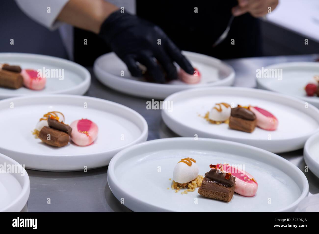 plated desserts in professional restaurant kitchen. chef arranges ...