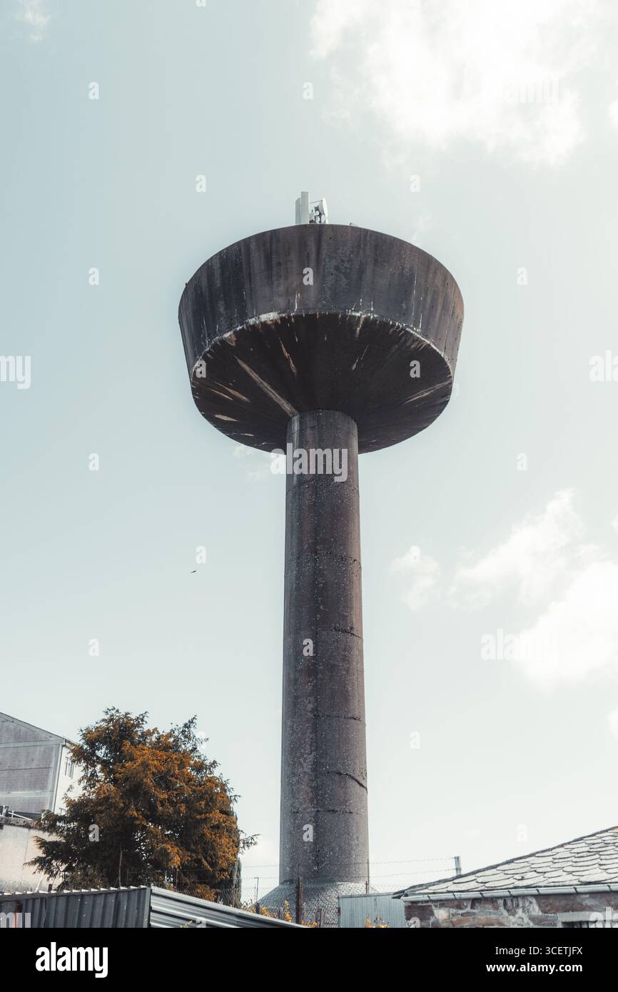 Tall concrete water tower shot from below in Fonsagrada, Spain, with ...