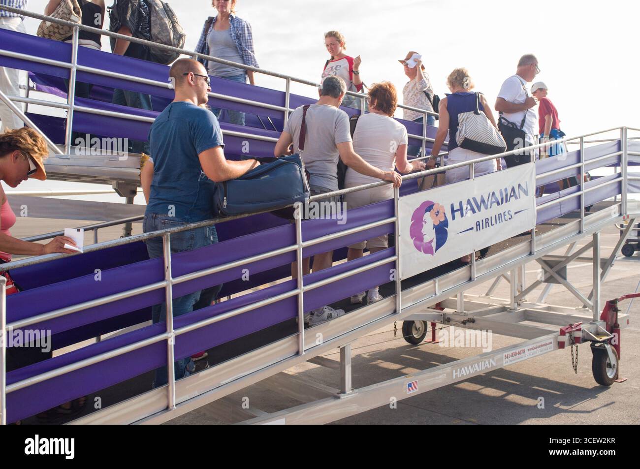 Passengers walking up ramp to board a Hawaiian Airlines jet aircraft ...
