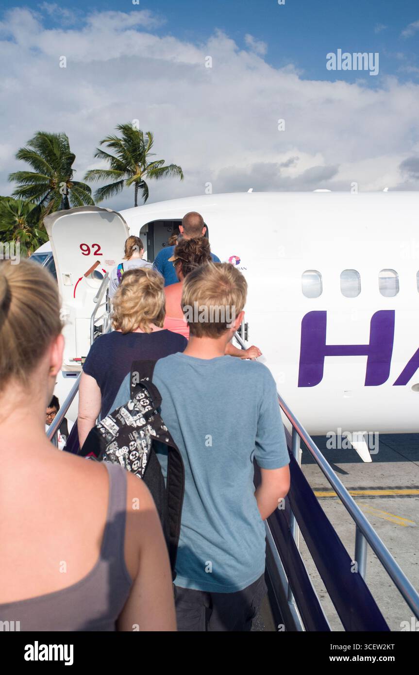 Passengers walking up ramp to board a Hawaiian Airlines jet aircraft ...