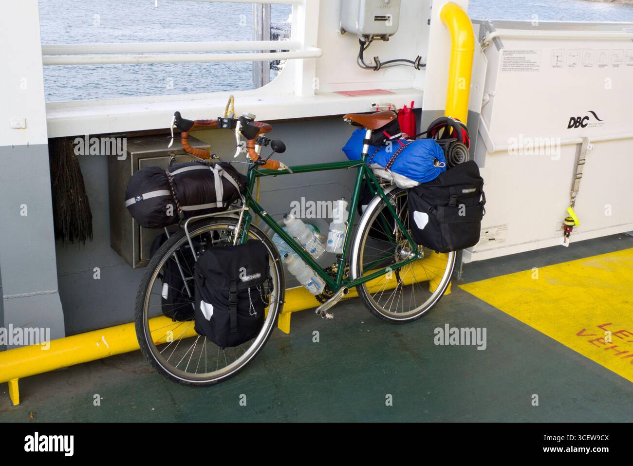Touring bicycle with panniers on front and back racks holding camping ...