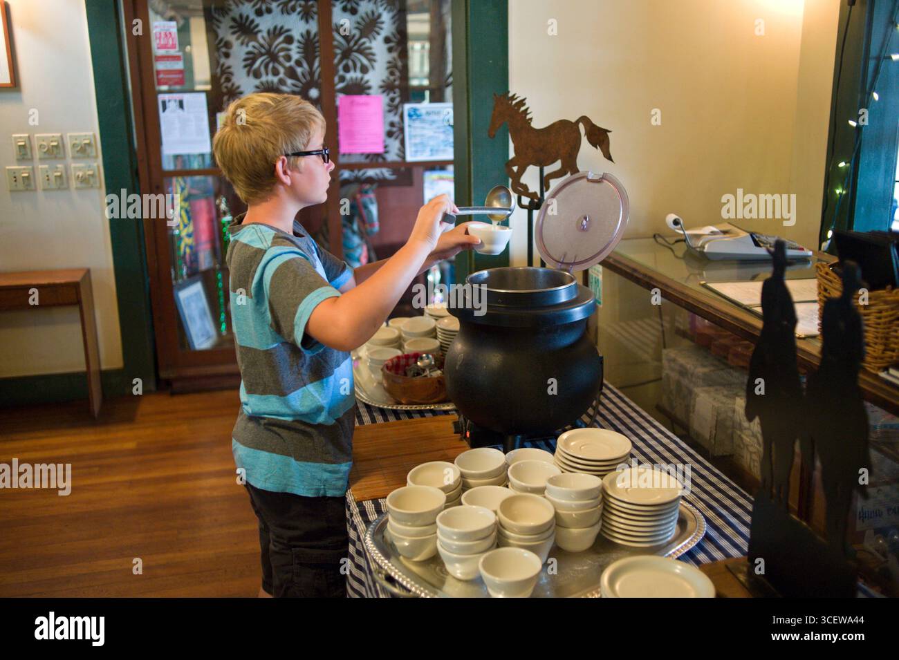 Boy ladling soup into his bowl, Wranglers Steakhouse, Waimea, Kauai ...