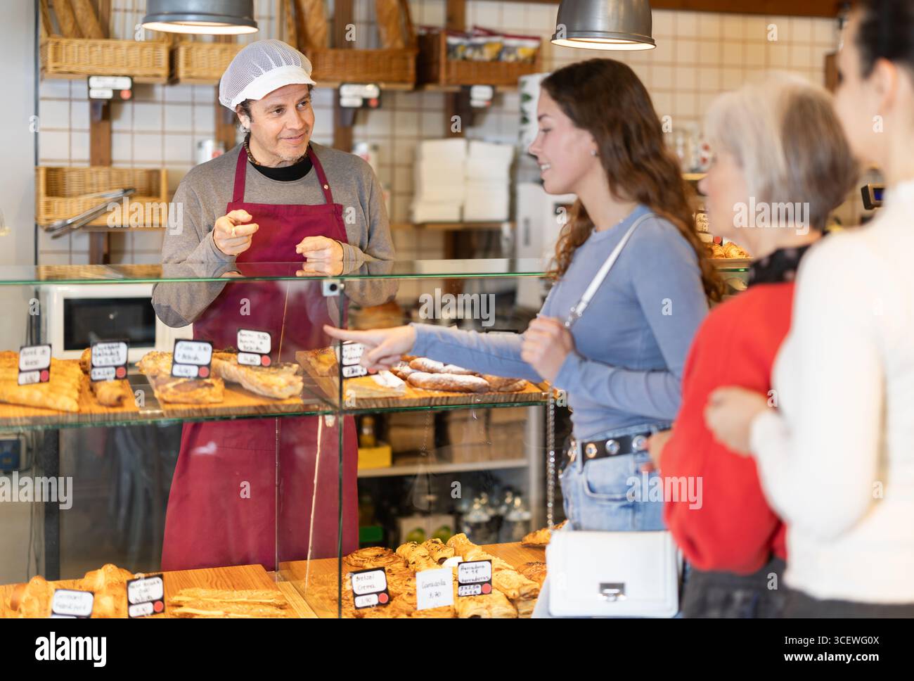 Salesman offers bakery customers to buy baked goods Stock Photo - Alamy