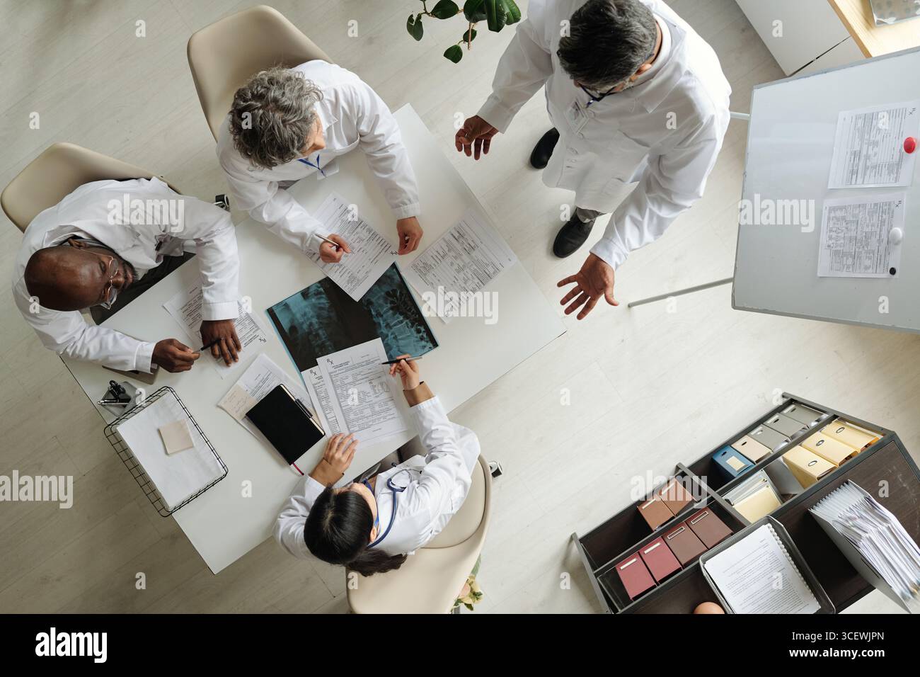 Collaborating team analyzing patient hi-res stock photography and ...