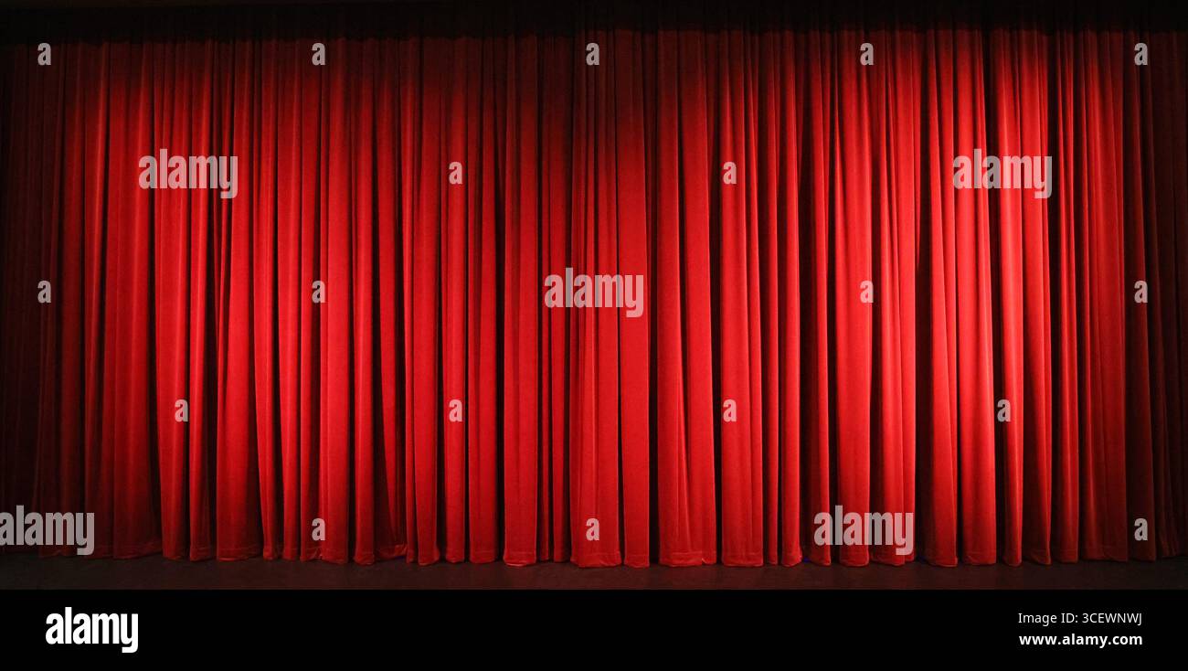 Beautiful full-length luxurious traditional red burgundy stage curtains on a theatre stage with ...