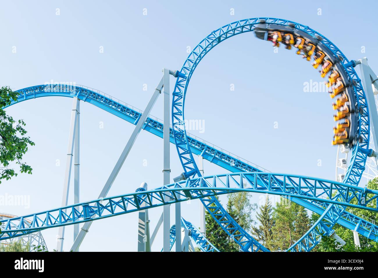 Roller coaster Ride against blue sky. Roller coaster in the amusement ...