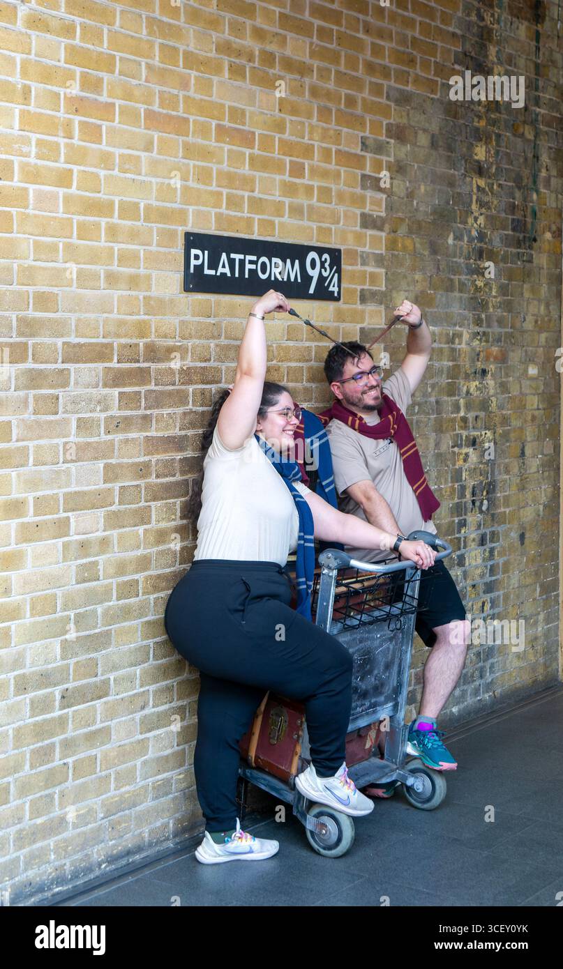 People posing for photos at Platform 9 ¾ Harry Potter location, King's ...