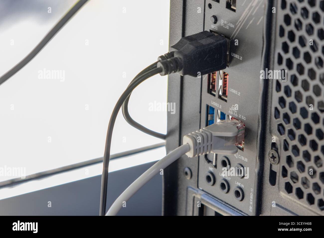Usb and ethernet cables plugged into ports on the back of a computer ...