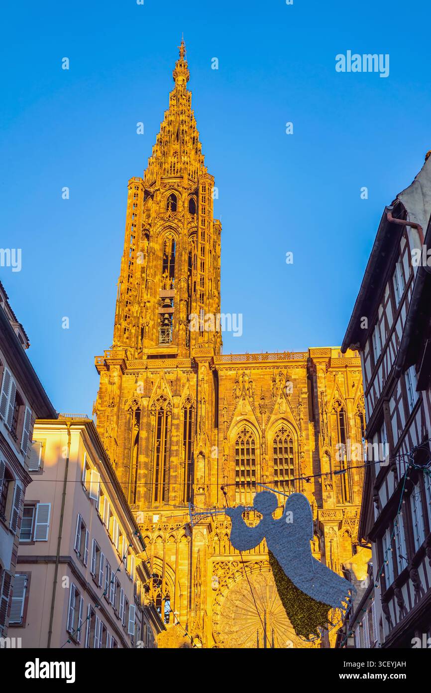 Sunlit Strasbourg Cathedral tower glows in golden tones with angel ...