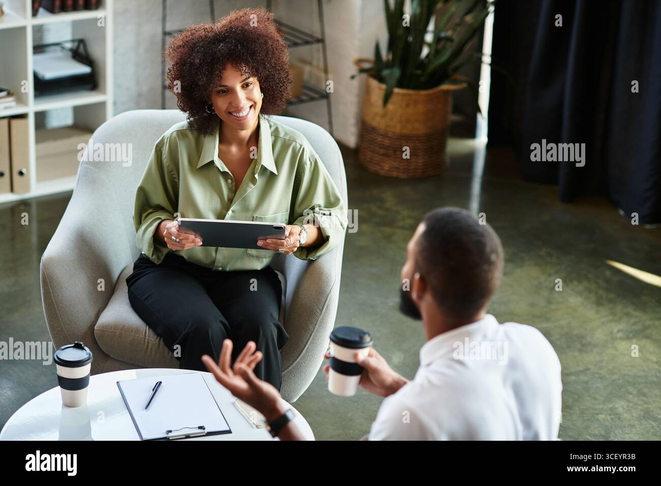 A young woman smiles while interviewing a candidate in a stylish studio ...