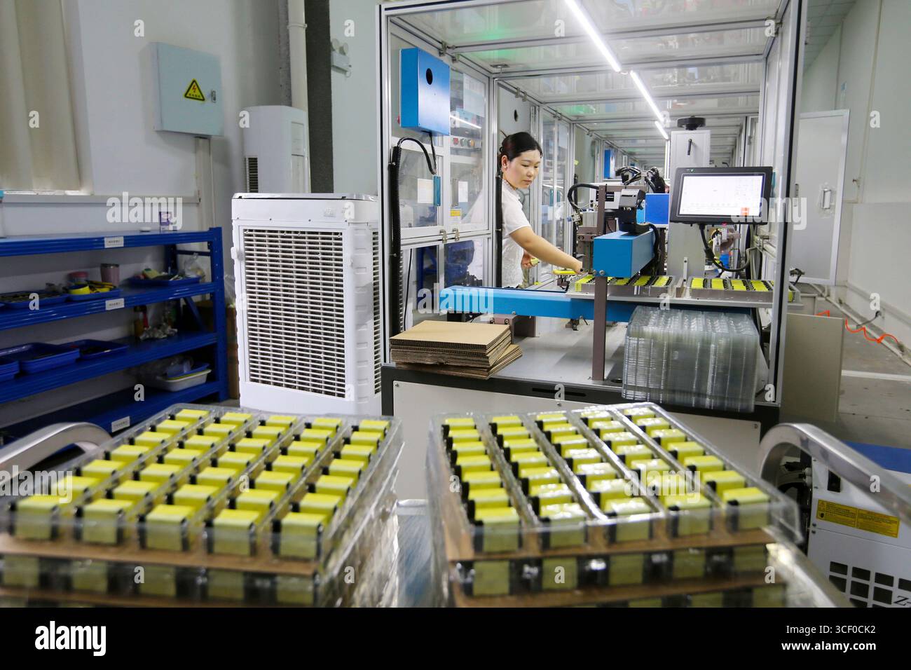 A woman works at an electronics factory in Suixi county in central ...