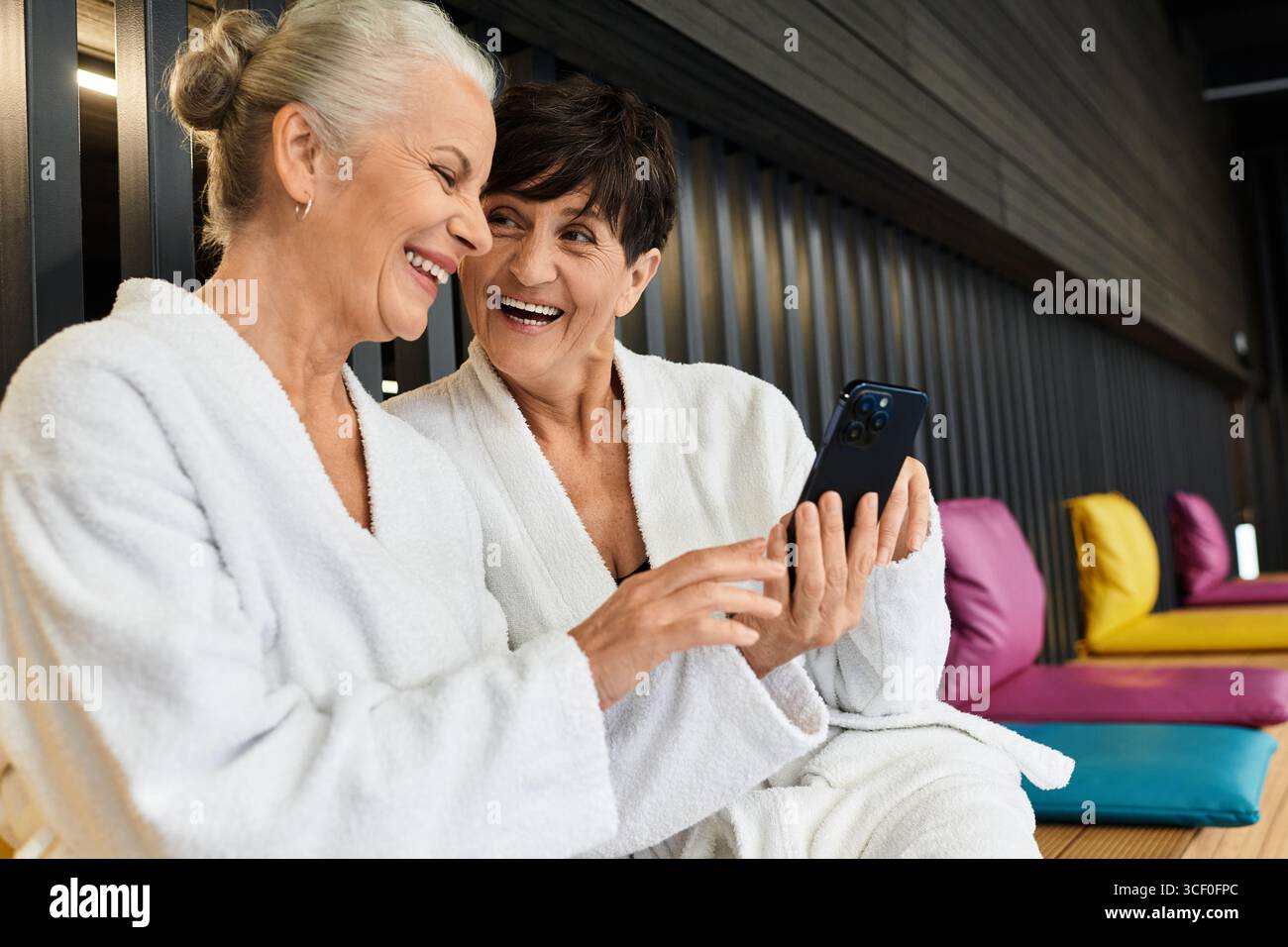 Two beautiful mature women enjoying relaxed moments while checking ...