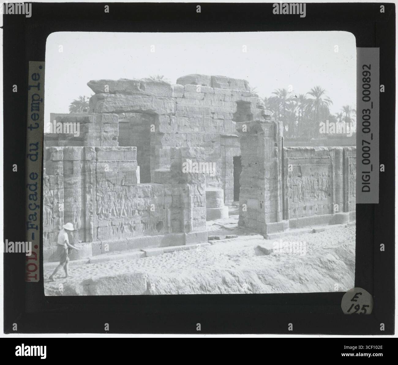 An archaeologist is seen walking in front of the façade of the pronaos ...