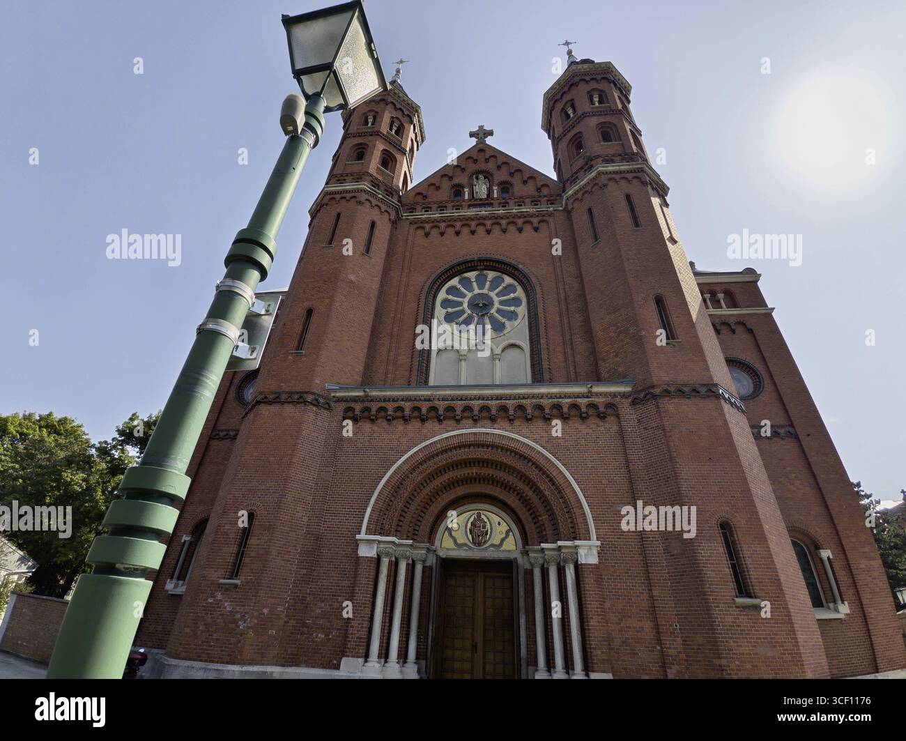 The impressive red brick facade of a church with dominating windows and ...