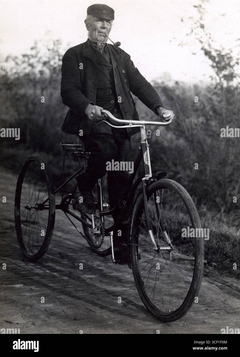An elderly man in traditional dress smokes a pipe while riding a ...