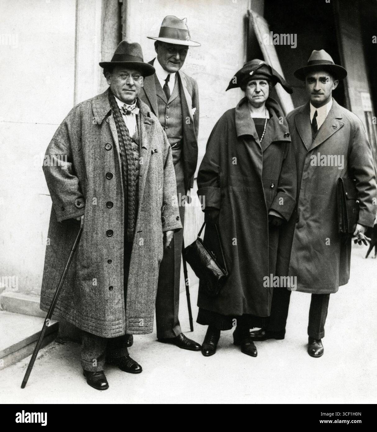 Conductor Willem Mengelberg, dressed in a long tweed coat, is seen with ...