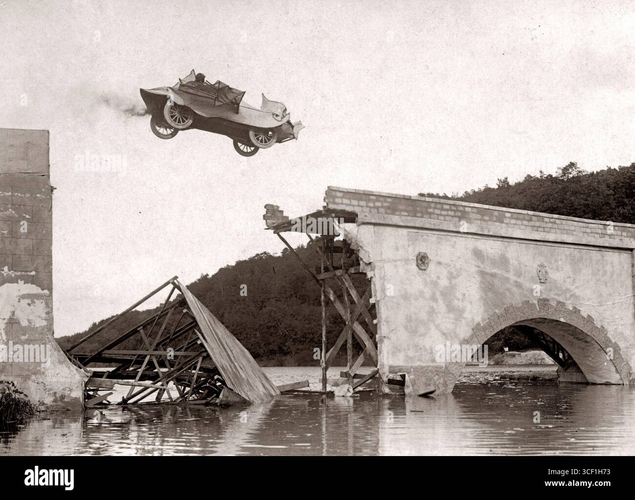 Outdoor film shoot featuring a car flying over a collapsed bridge. The ...
