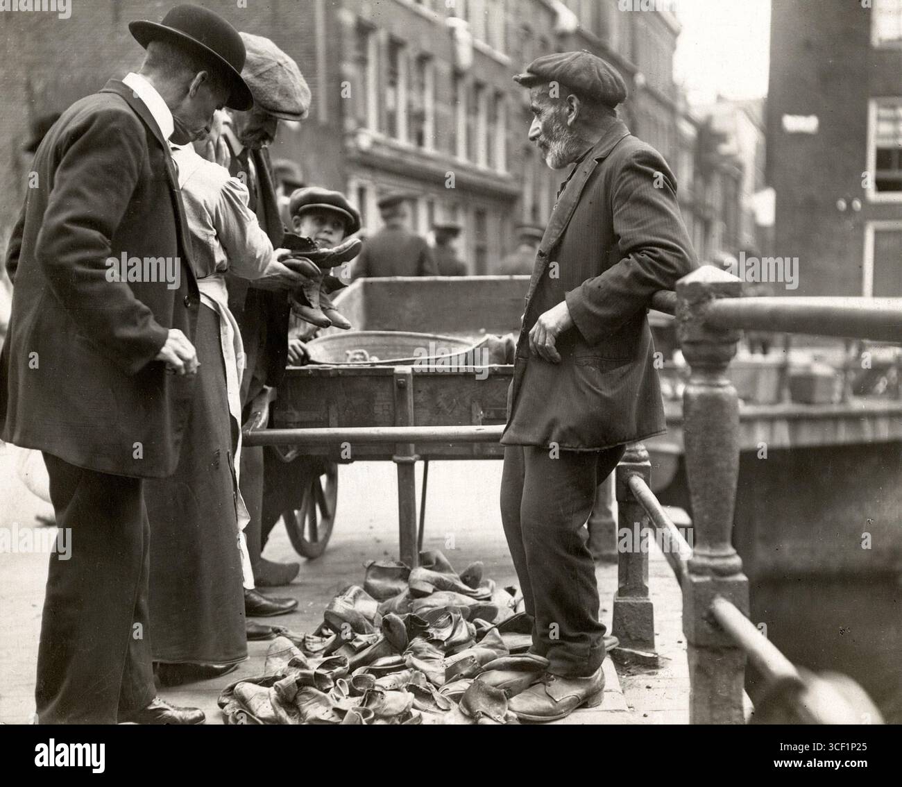 A merchant in Amsterdam, 1917, selling second-hand shoes from a cart ...