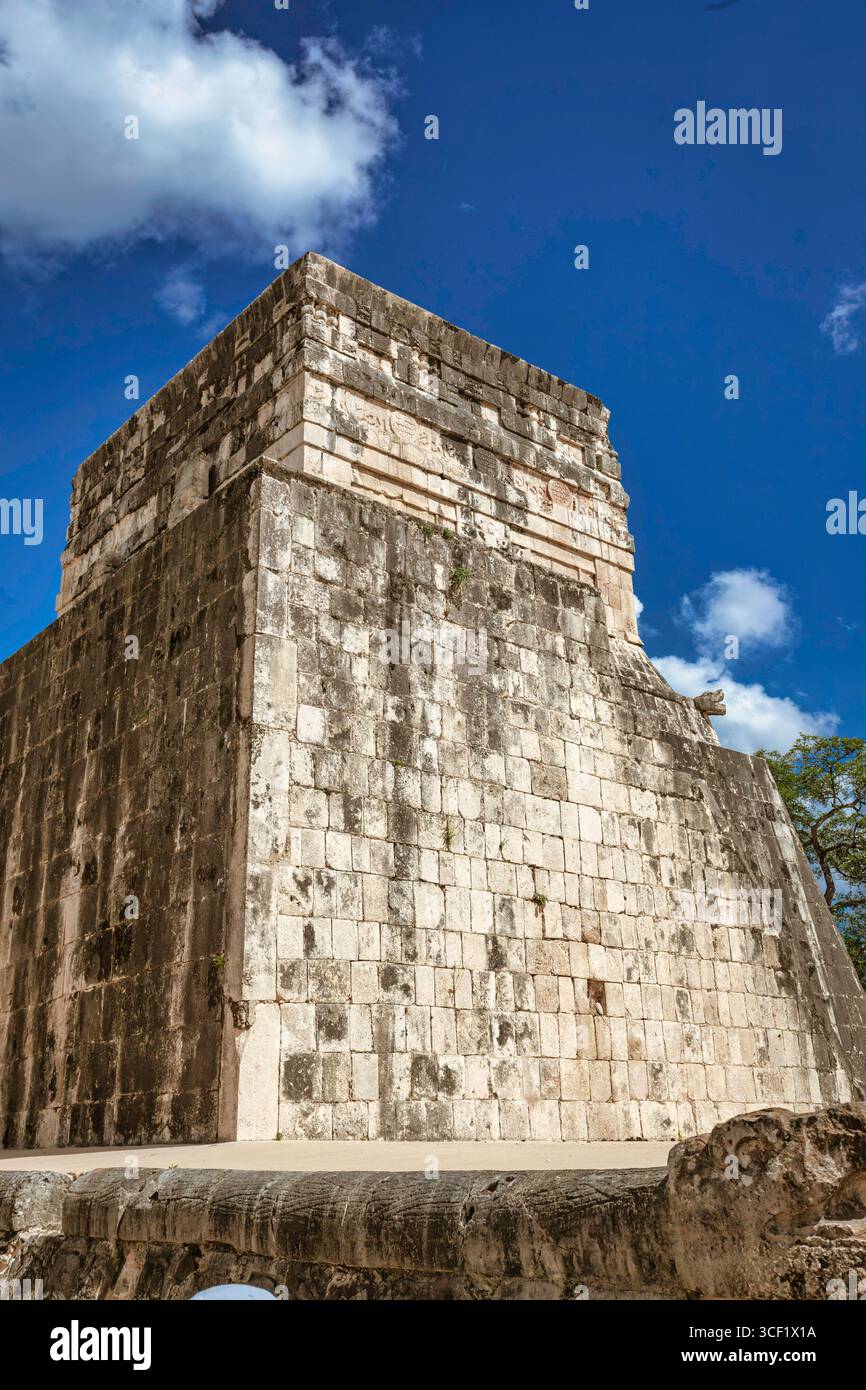 Impressive stone wall of the great ball court rising towards a vibrant ...
