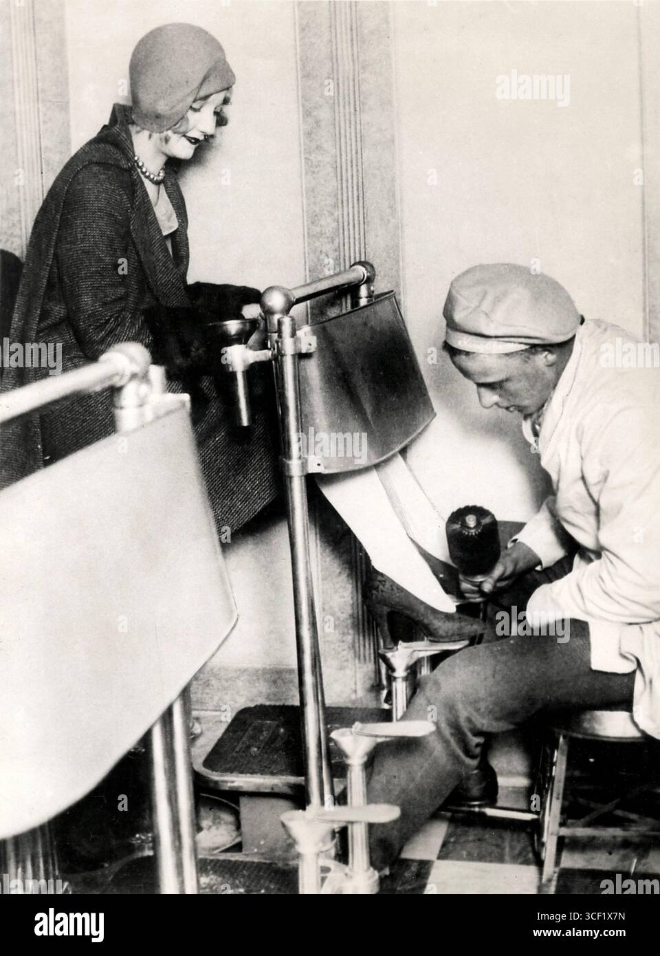 A screen is placed between a shoe polisher and the legs of a woman ...