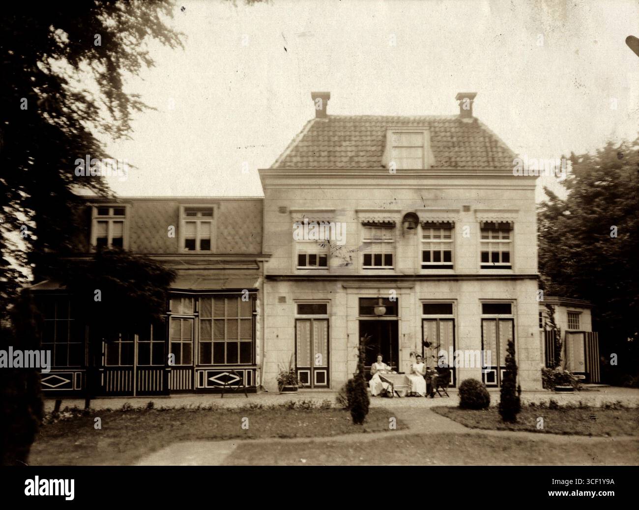 A 19th-century country house with a conservatory and an annex. On the ...