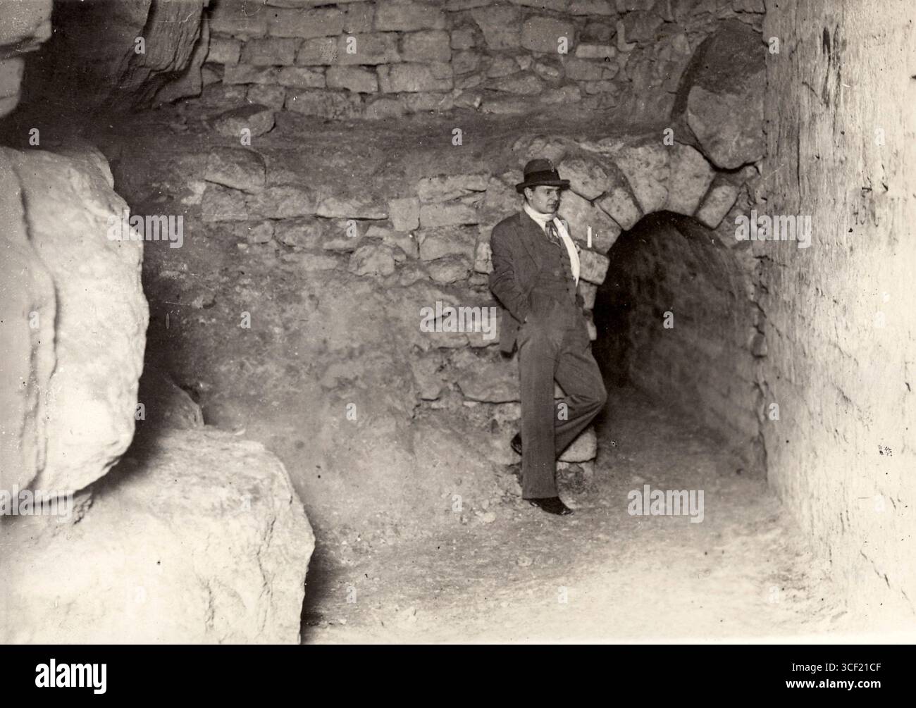In 1929, a man stands at the end of a corridor in the Paris Catacombs ...