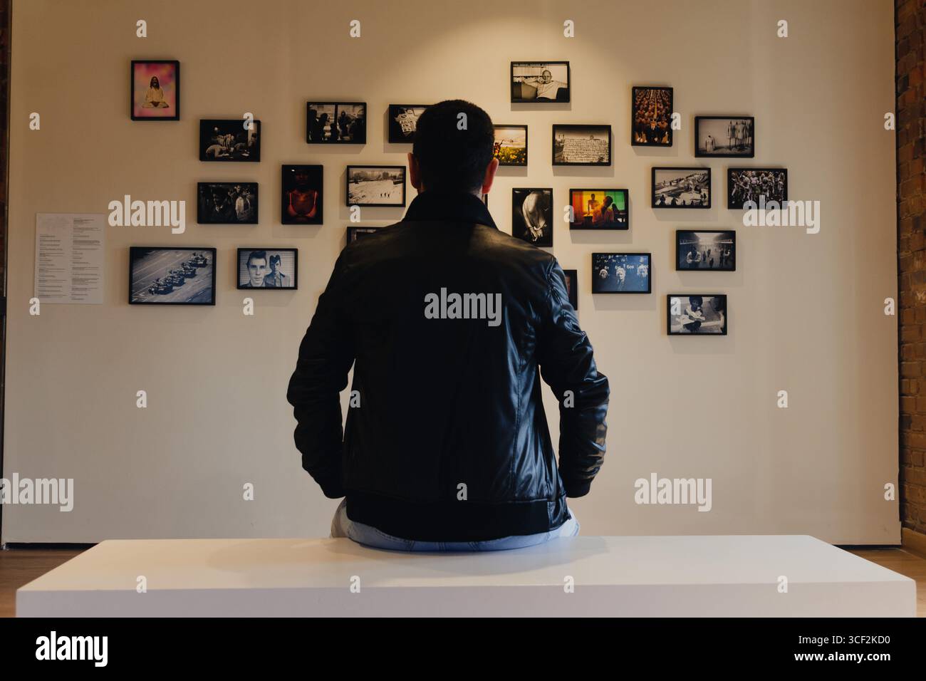 Urban gallery scene featuring man and wall of mixed media art from ...