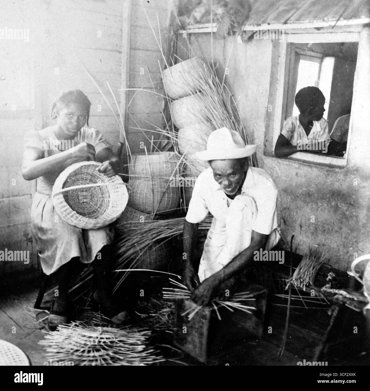 This photograph, taken between 1910 and 1950, shows basket weavers ...