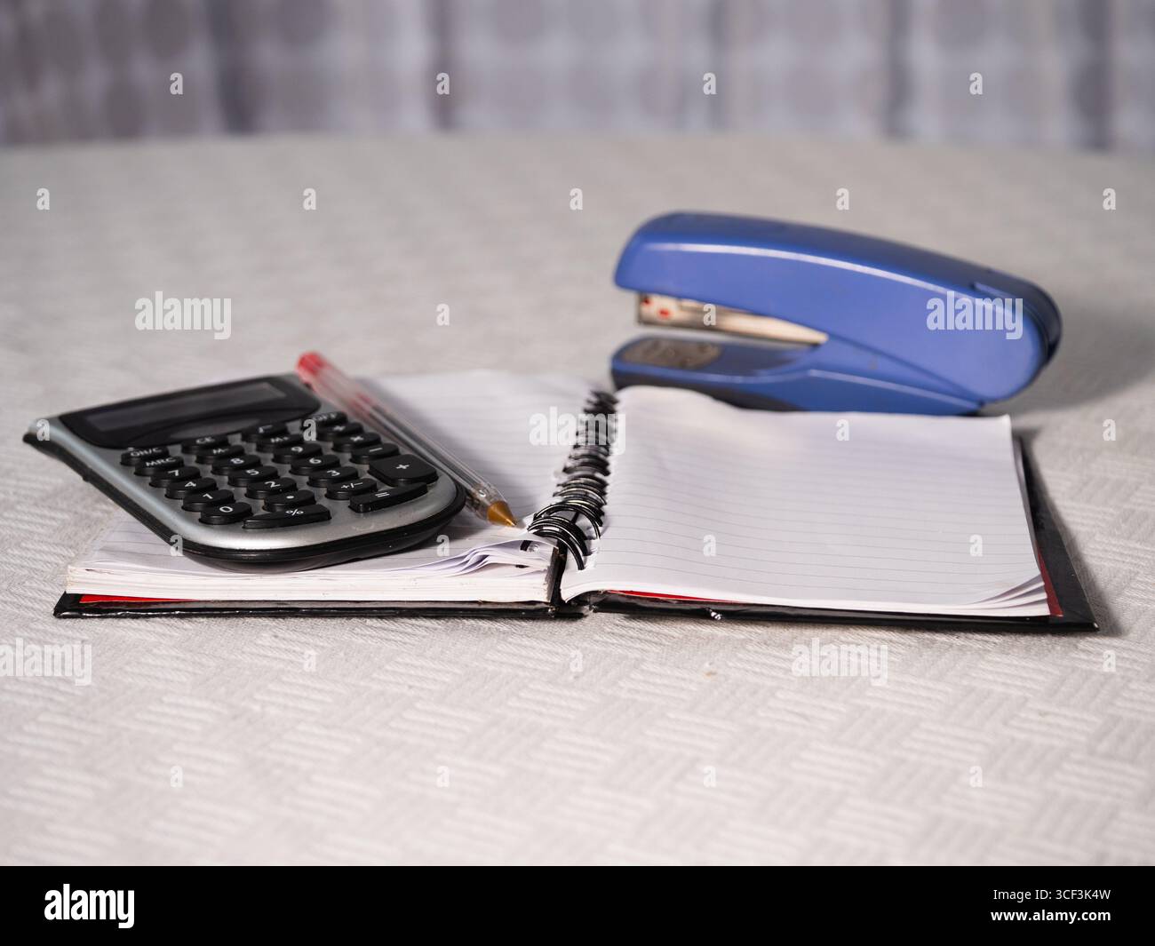Notepad paper blowing in office with calculator Stock Photo - Alamy