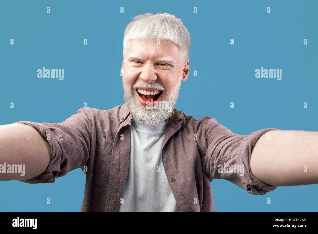 Happy albino guy with unusual appearance taking selfie on turquoise ...