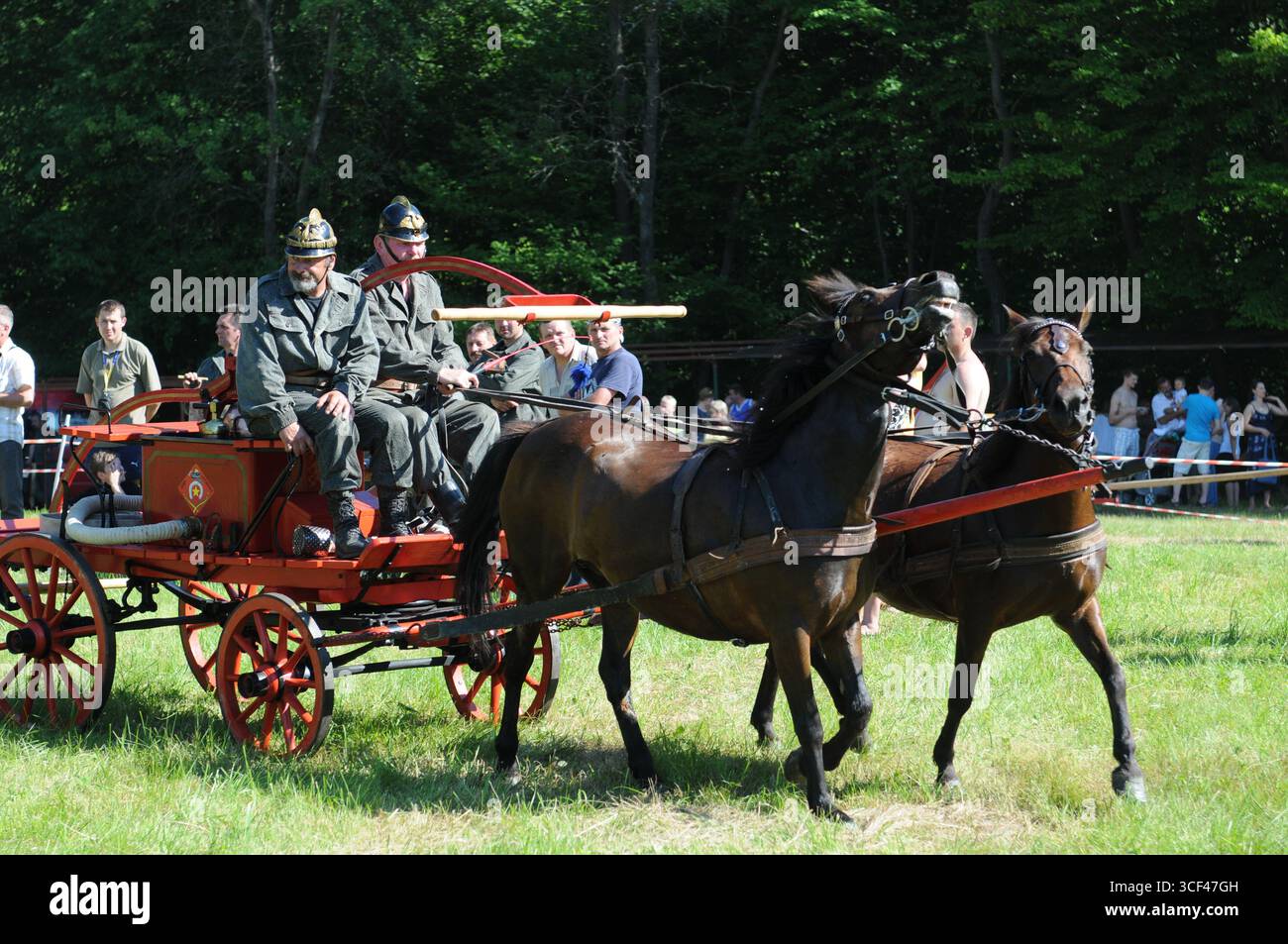 Firefighters riding a historic horse-drawn fire engine during ...