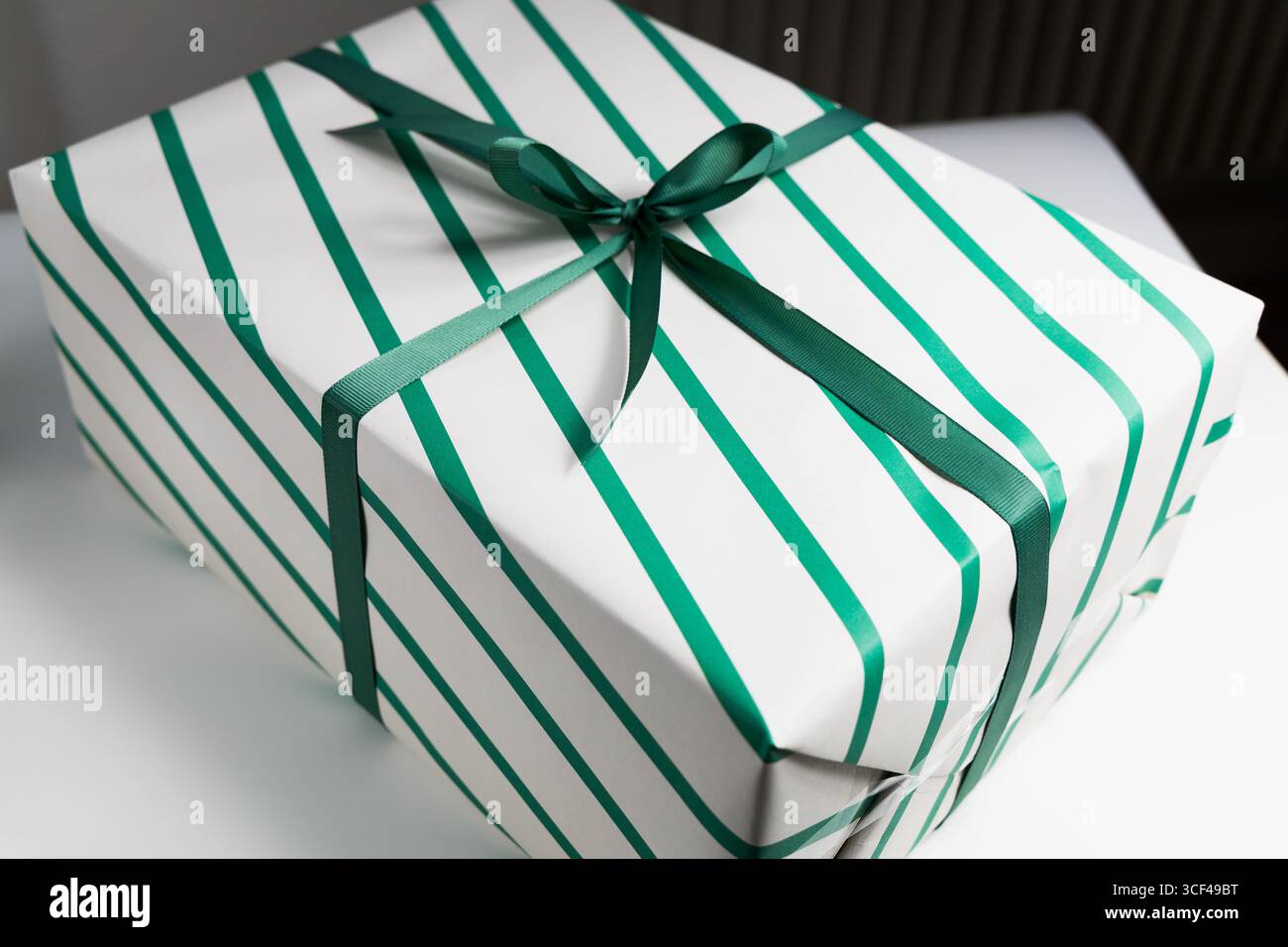 Green striped gift box with festive wrapping ribbon. High quality photo ...