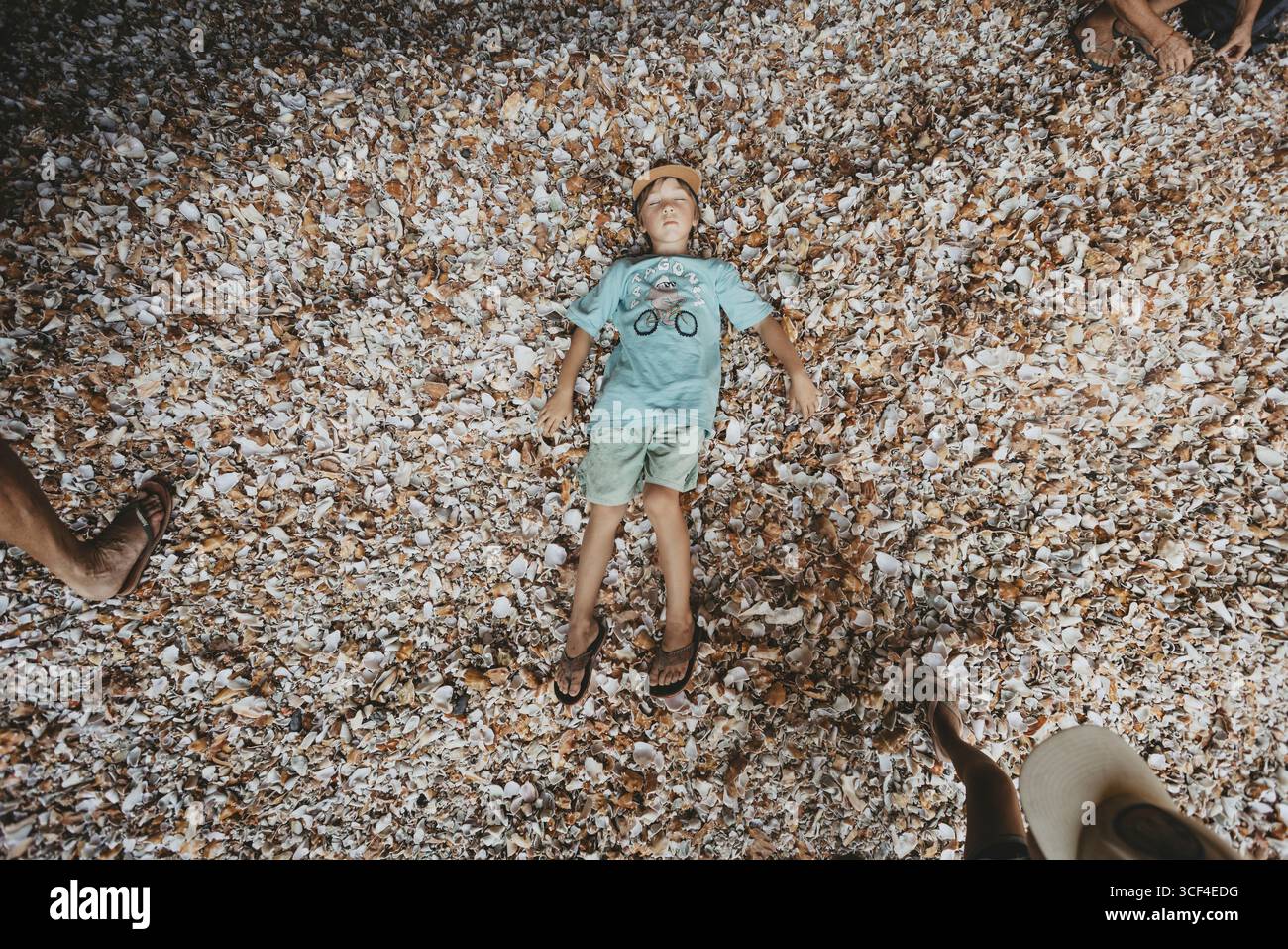 Boy lying on shells on the coast of the small Cape Verde island of ...