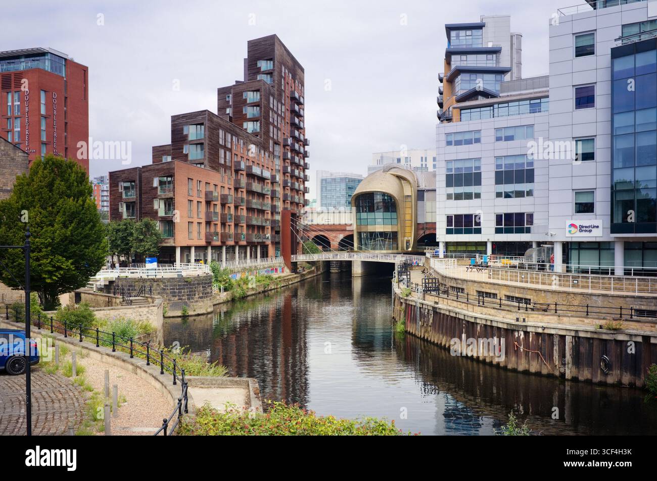 Leeds river lock and high rise buildings on and over the river Aire ...
