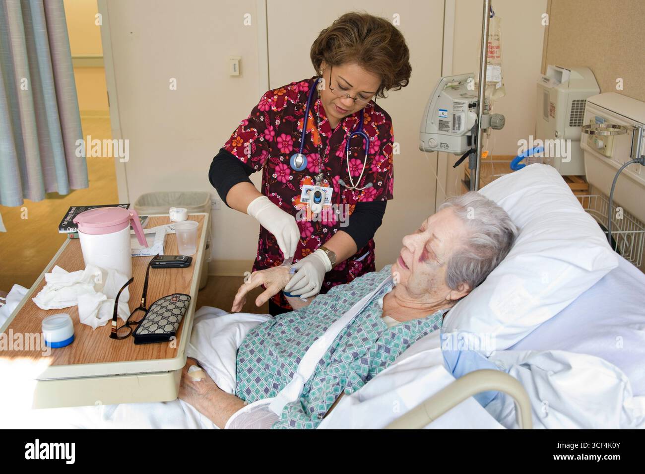Female nurse removing needle and tubes used for intravenous therapy ...