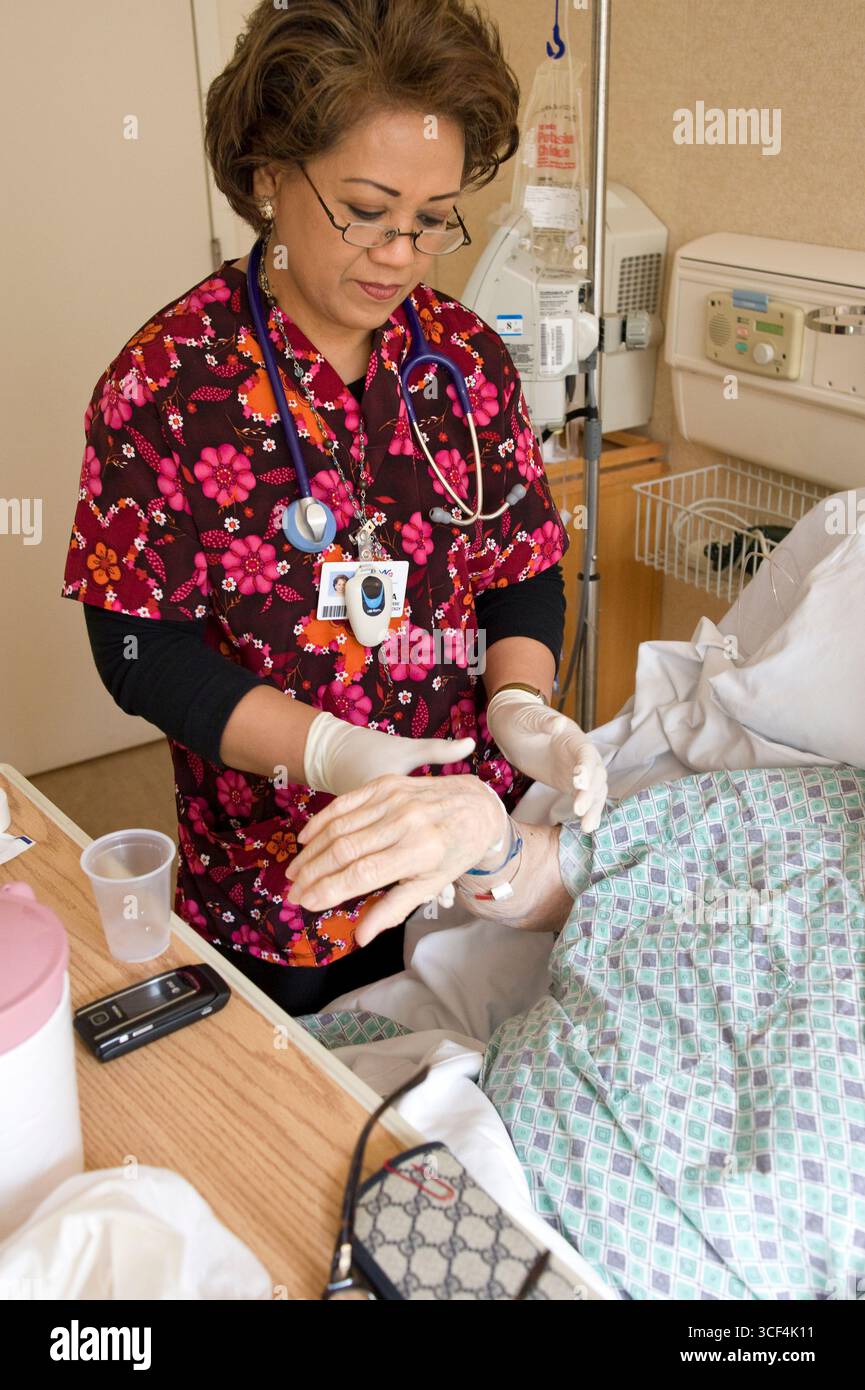 Female nurse removing needle and tubes used for intravenous therapy ...