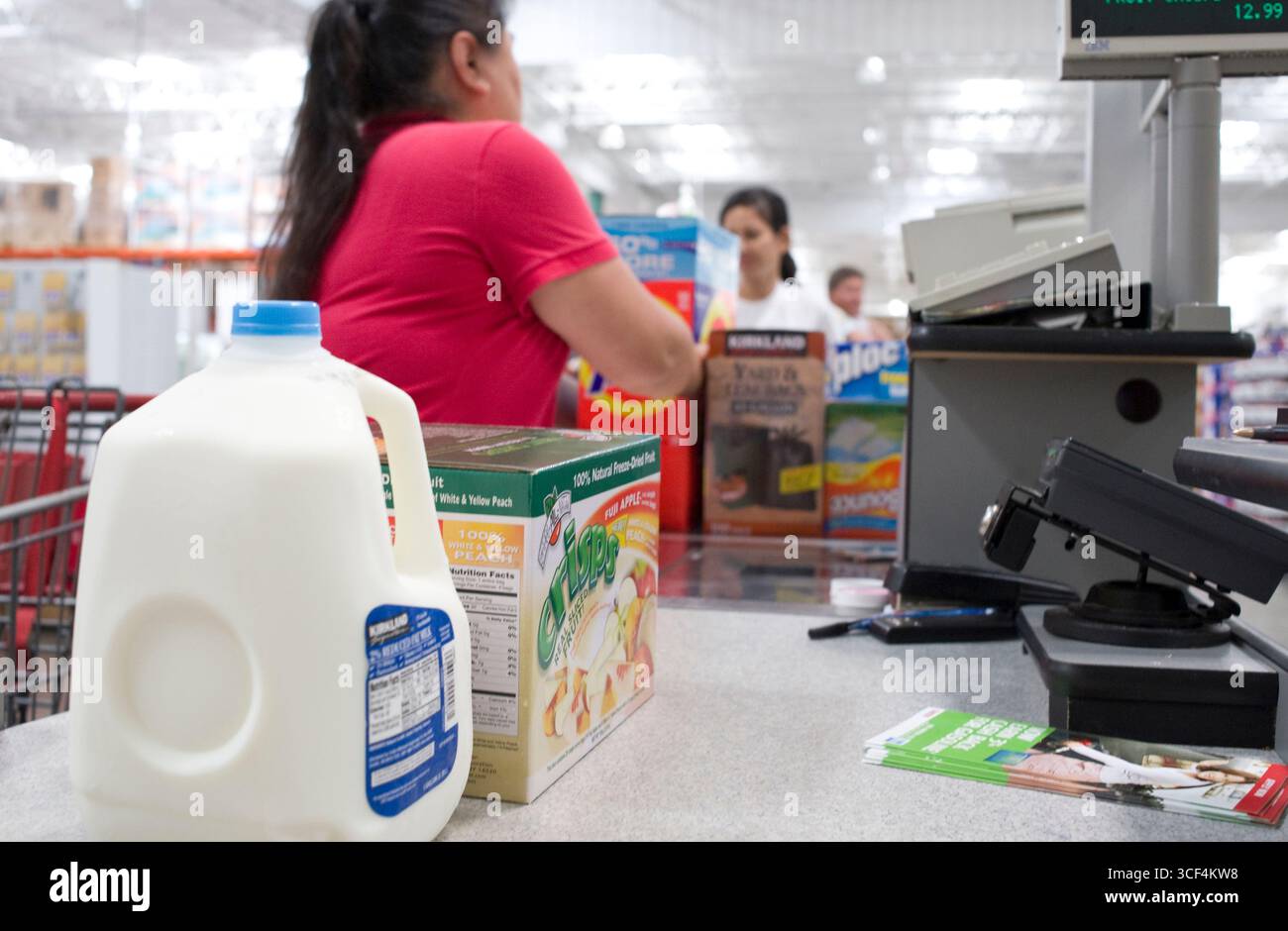 Woman working at checking out scanning items at register at a Costco ...